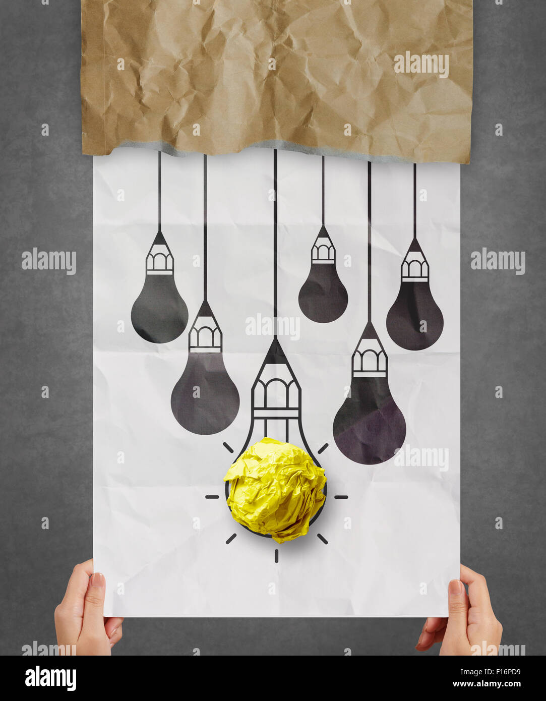 hand pulling light bulb crumpled paper out of recycle envelope as ...