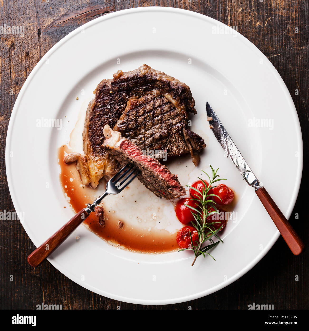 Sliced medium rare grilled Beef steak Ribeye with grilled cherry ...