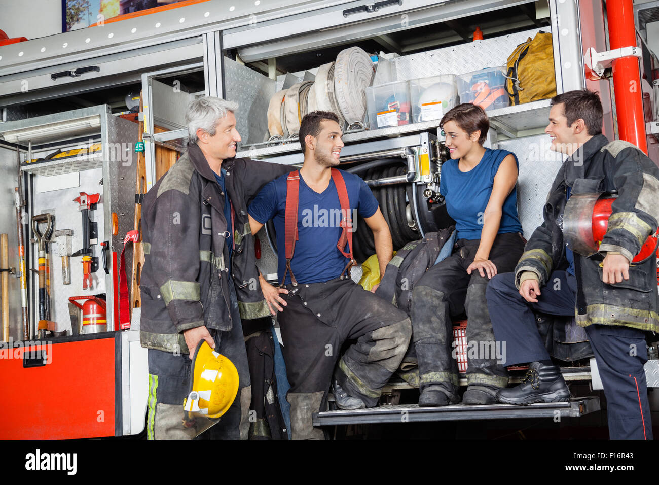 Firefighters Communicating By Firetruck At Station Stock Photo - Alamy