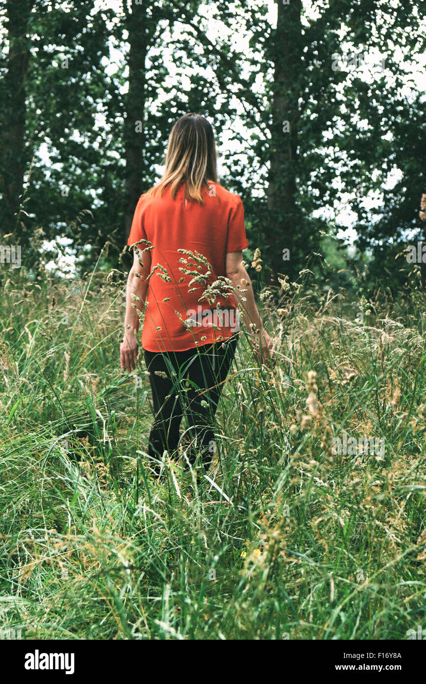 Woman walking through grass hi-res stock photography and images - Alamy