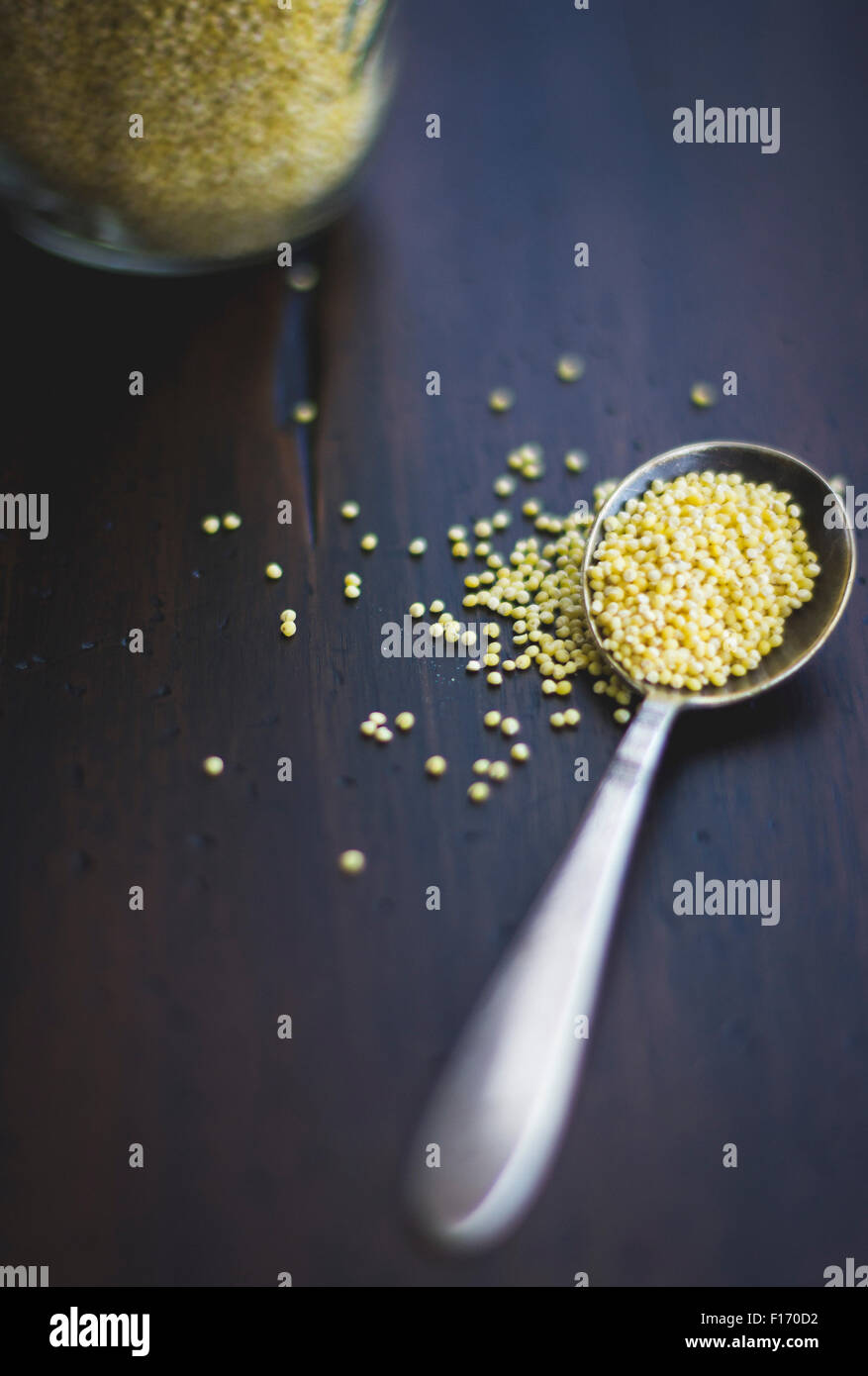 Raw millet in soup spoon on wood Stock Photo - Alamy