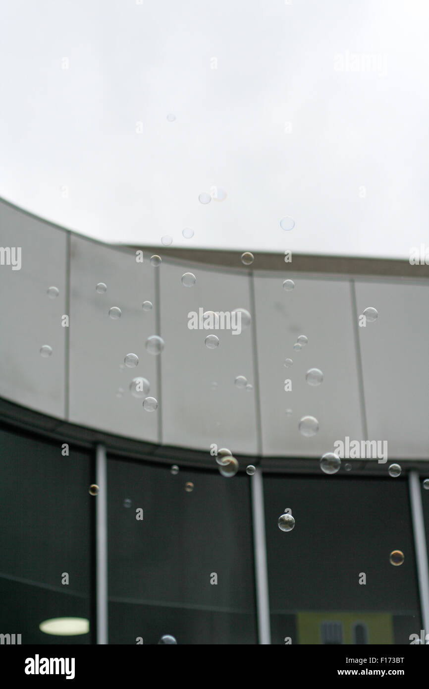 Bubbles floating in the air with modern building behind Stock Photo - Alamy