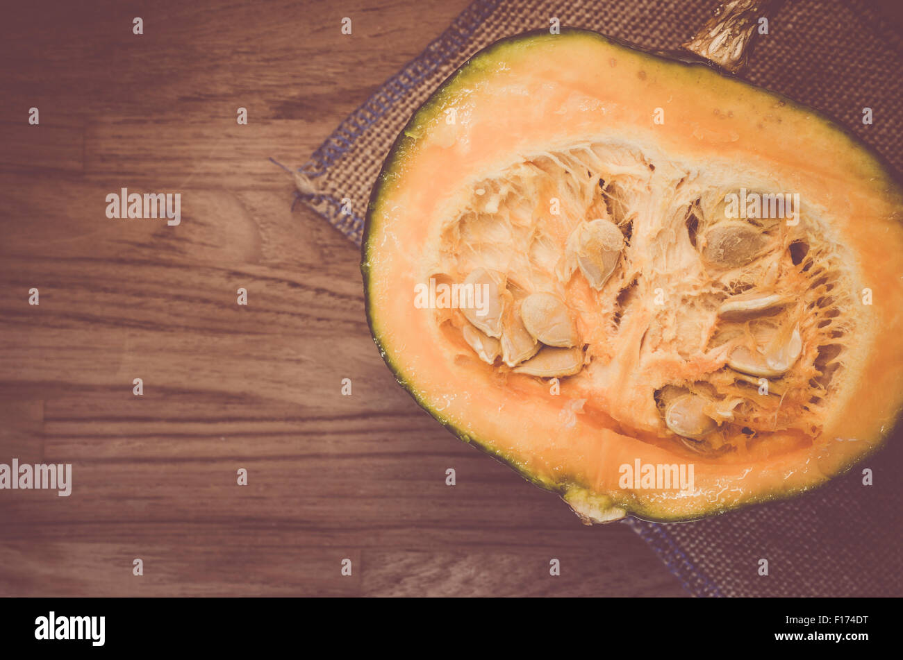 fresh and ripe half cut pumpkin on a natural wood background - organic ...