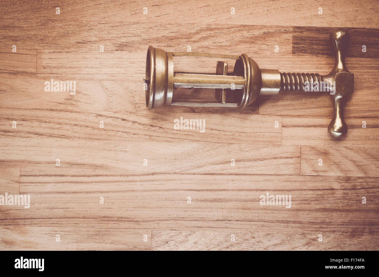 old hand made solid brass corkscrew on a natural wood background ...