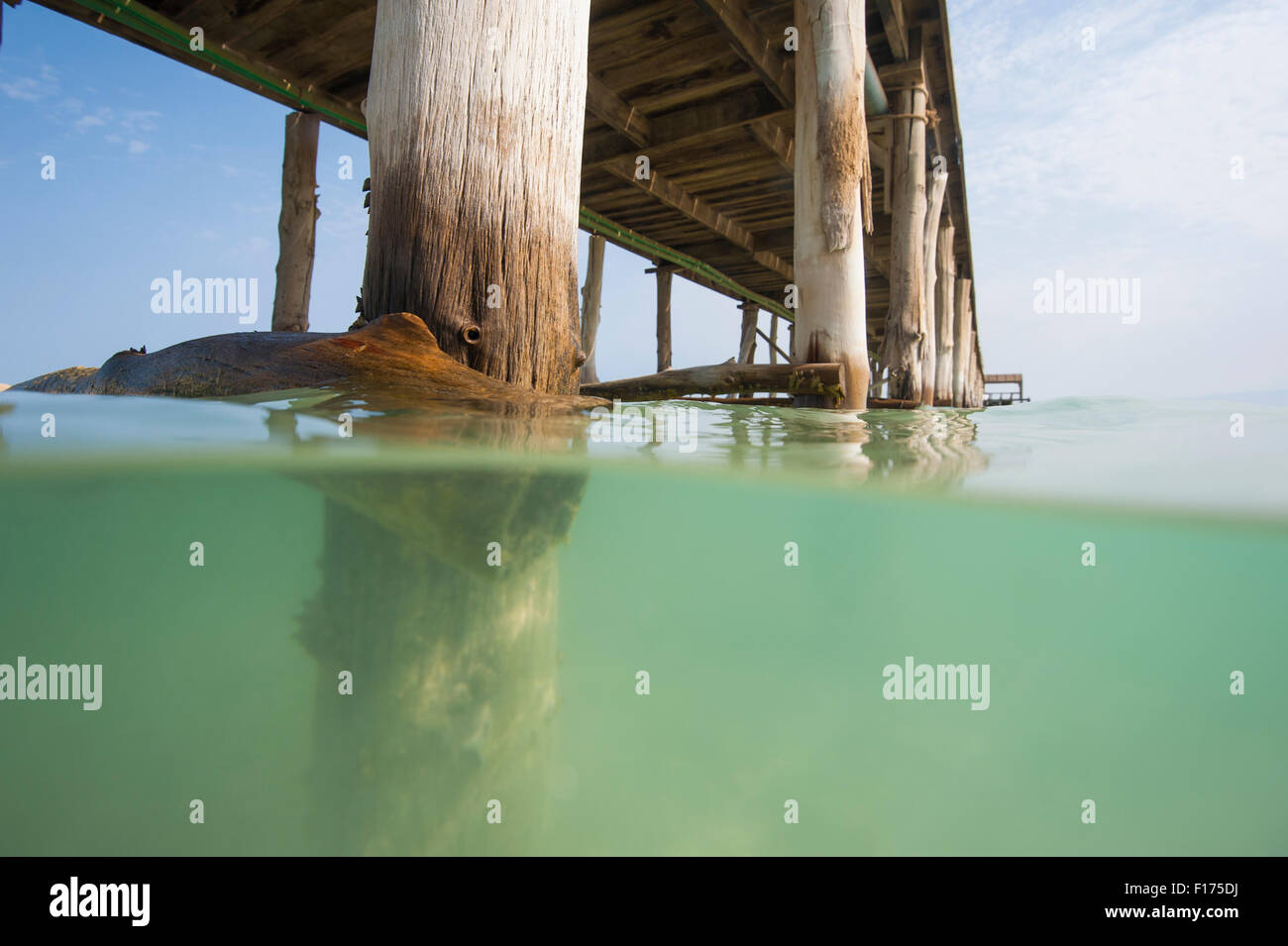 Long wooden jetty in the sea from a tropical island lagoon on beach ...