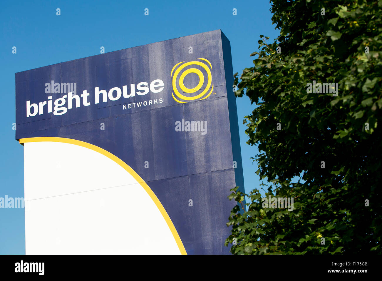 A logo sign outside of a facility occupied by Bright House Networks in ...