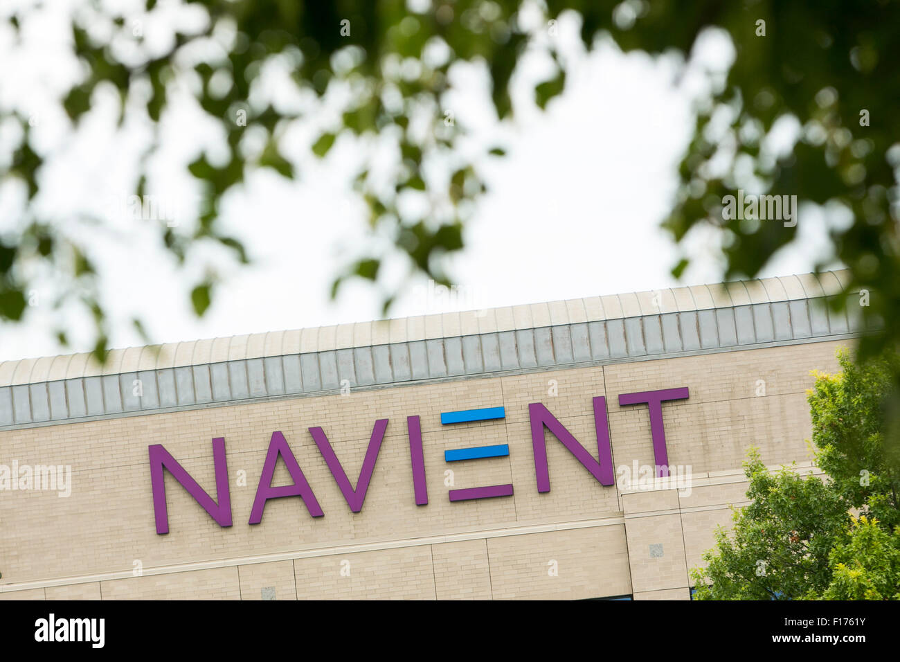 A logo sign outside of a facility occupied by the Navient Corporation ...
