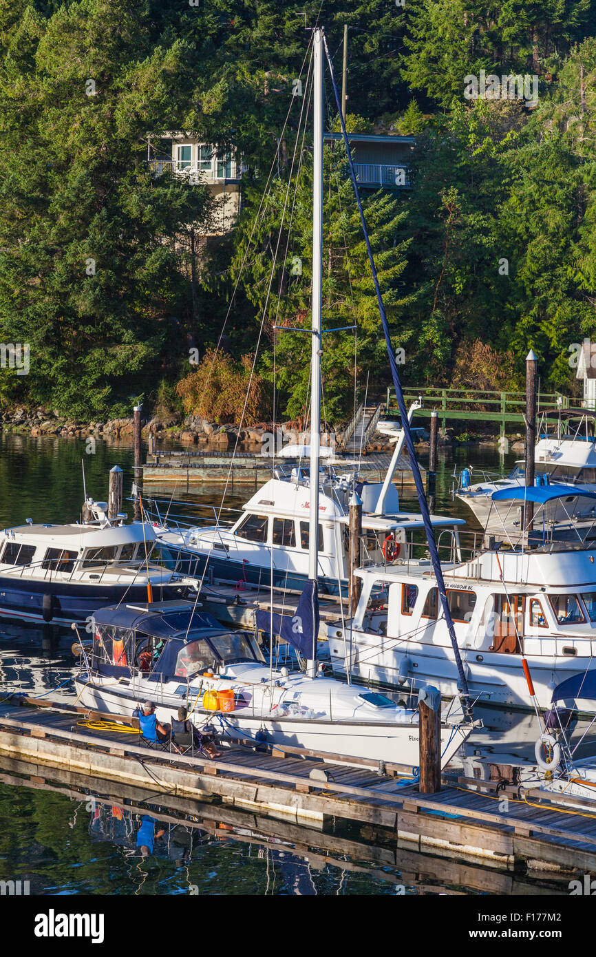 Evening light on sailing vessels docked in a quiet bay of Pender ...