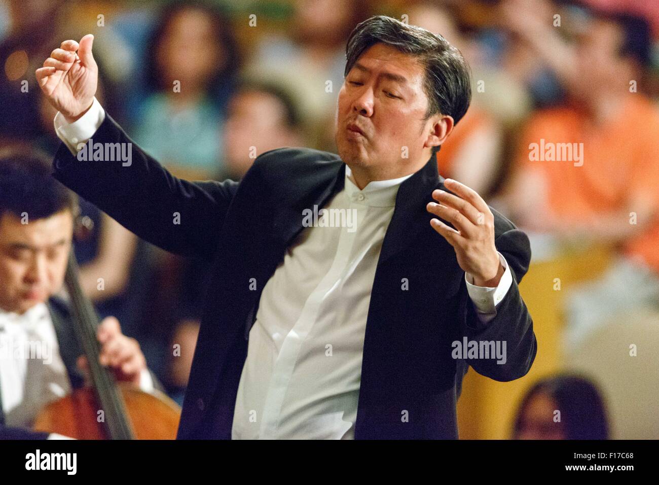 New York, USA. 28th Aug, 2015. Maestro Long Yu leads an orchestra in a ...