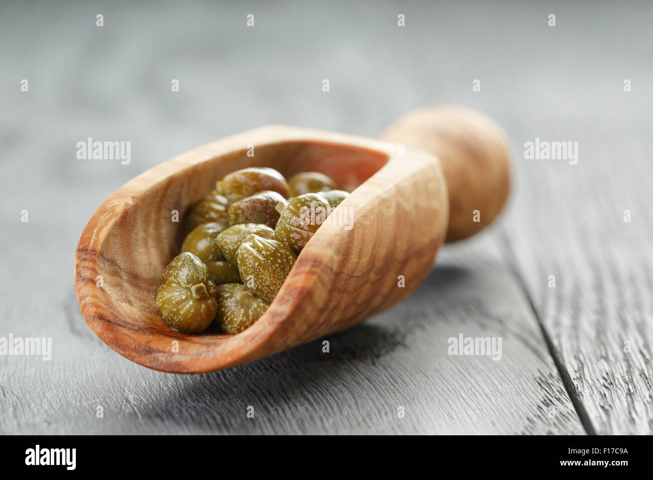 marinated capers in wood scoop on table Stock Photo - Alamy