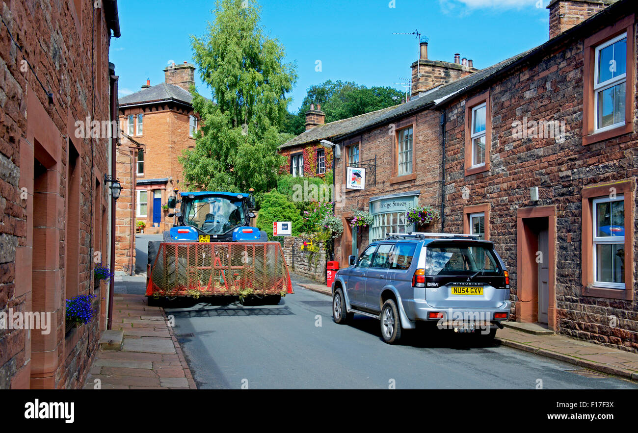 Tractor passing parked car in the village of Kirkoswald, Eden Valley ...