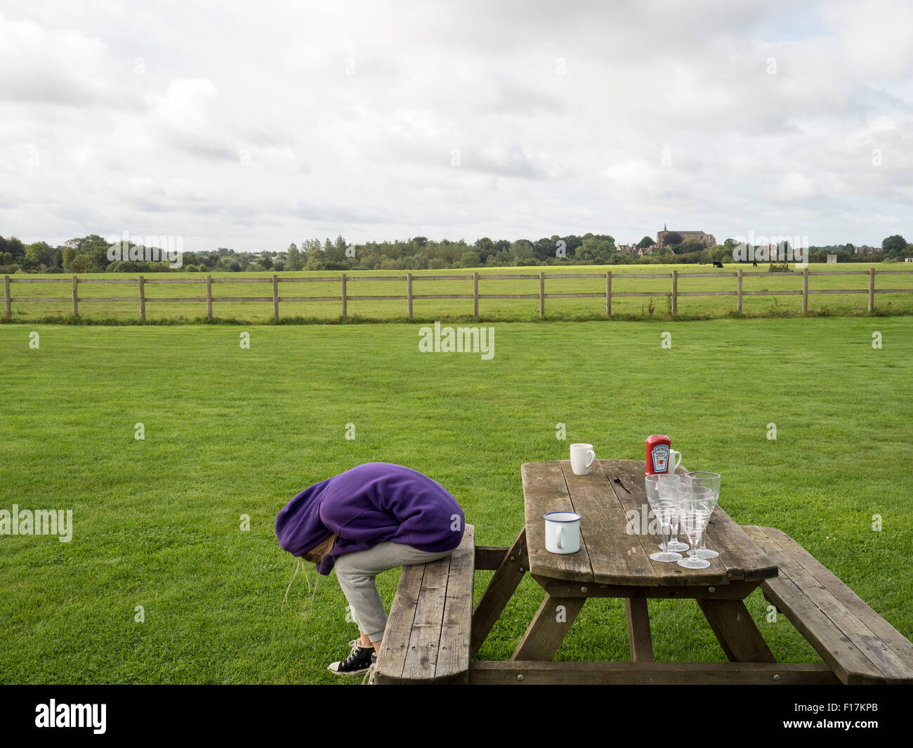 A ten year old girl being sad at a picnic table on a camping holiday in ...