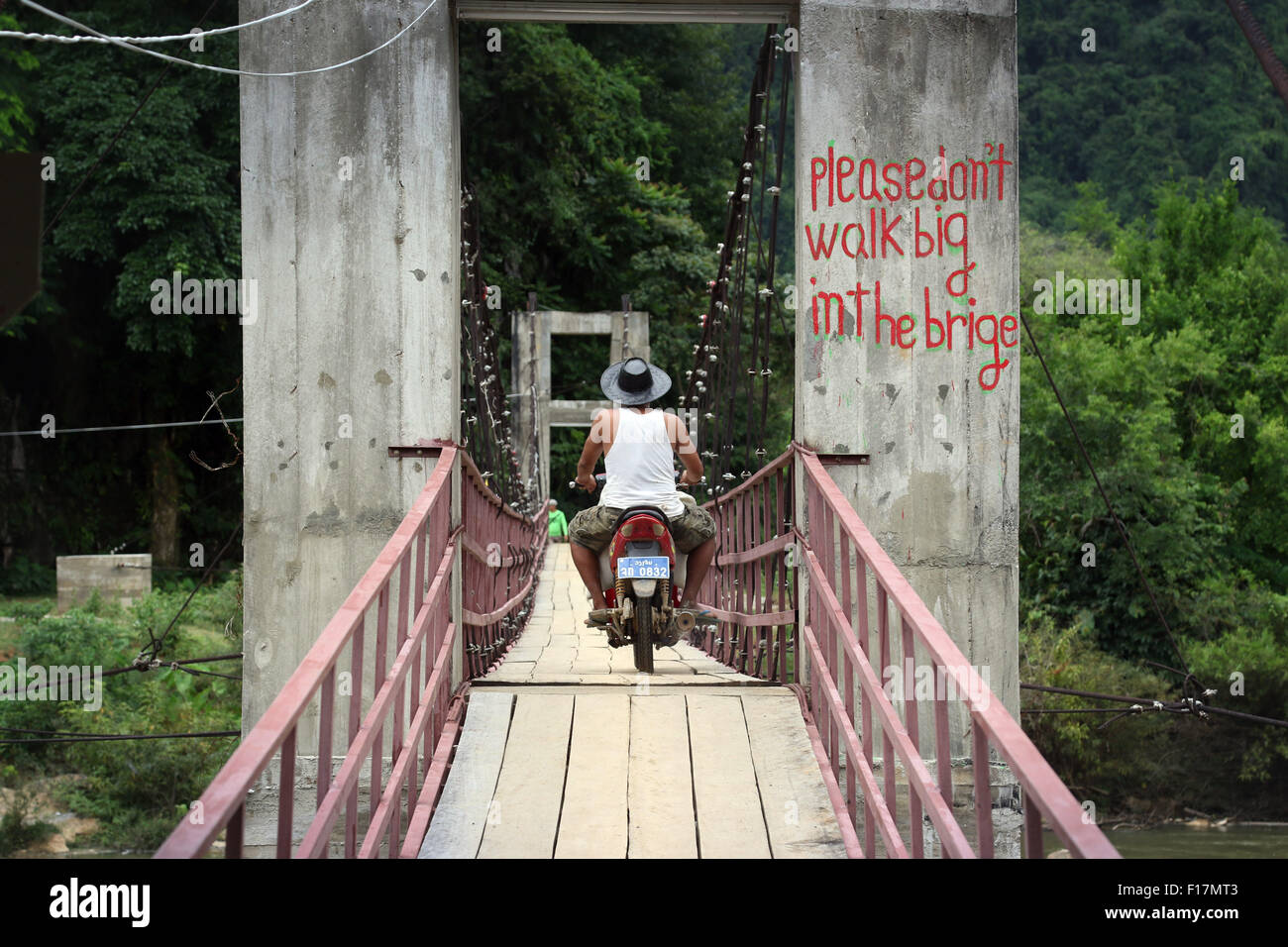 Man crossing wooden bridge on scooter narrow rustic Stock Photo - Alamy
