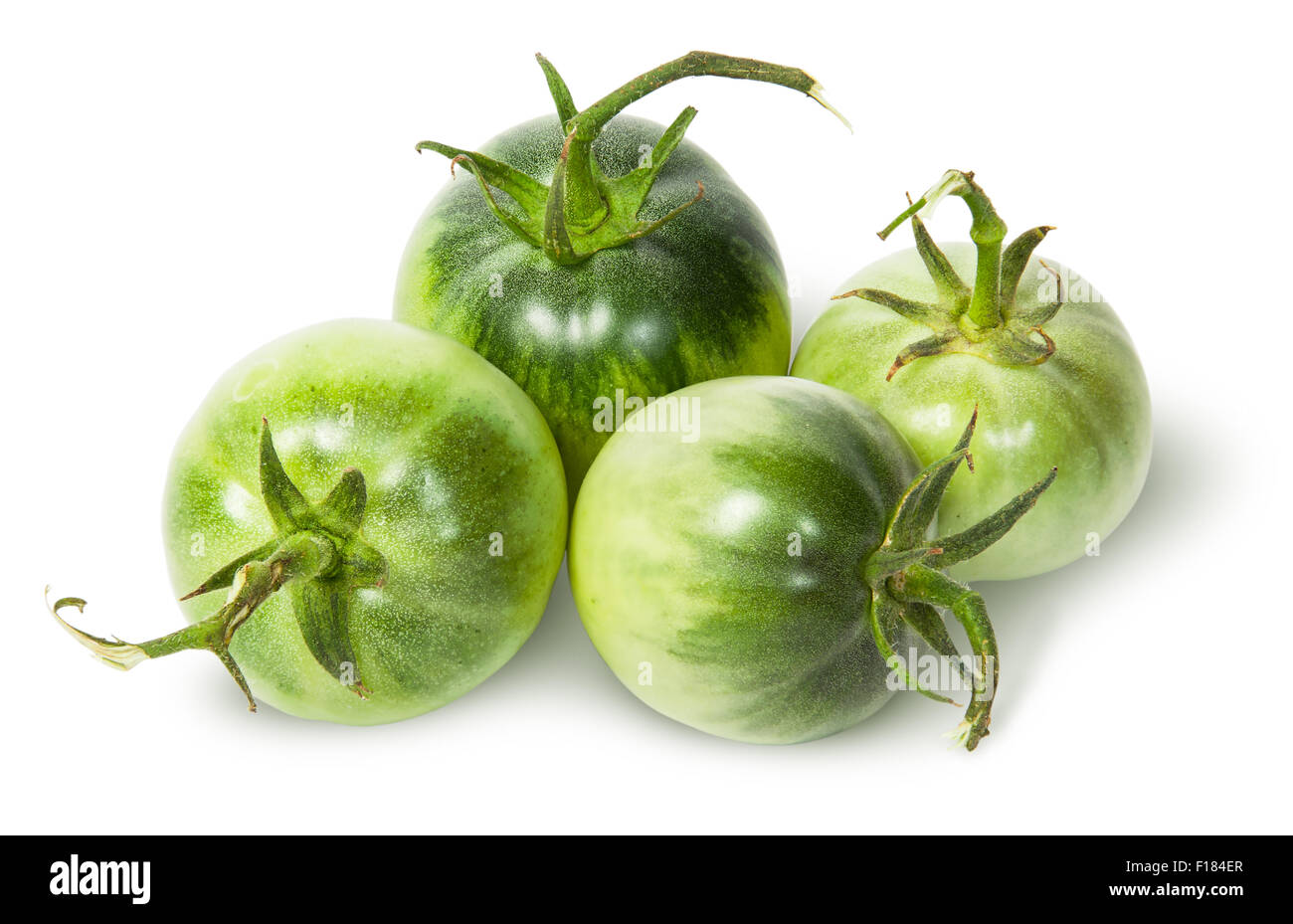 Four green tomatoes near isolated on white background Stock Photo - Alamy