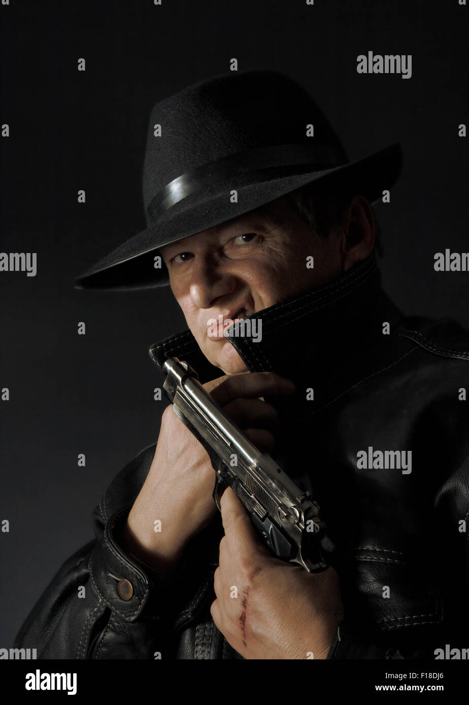 Dangerous looking mafia type with revolver and leather jacket Stock ...
