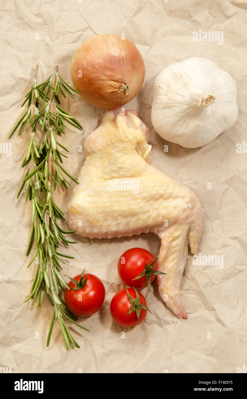 raw chicken wing with onion, garlic, cherry tomato and rosemary on ...