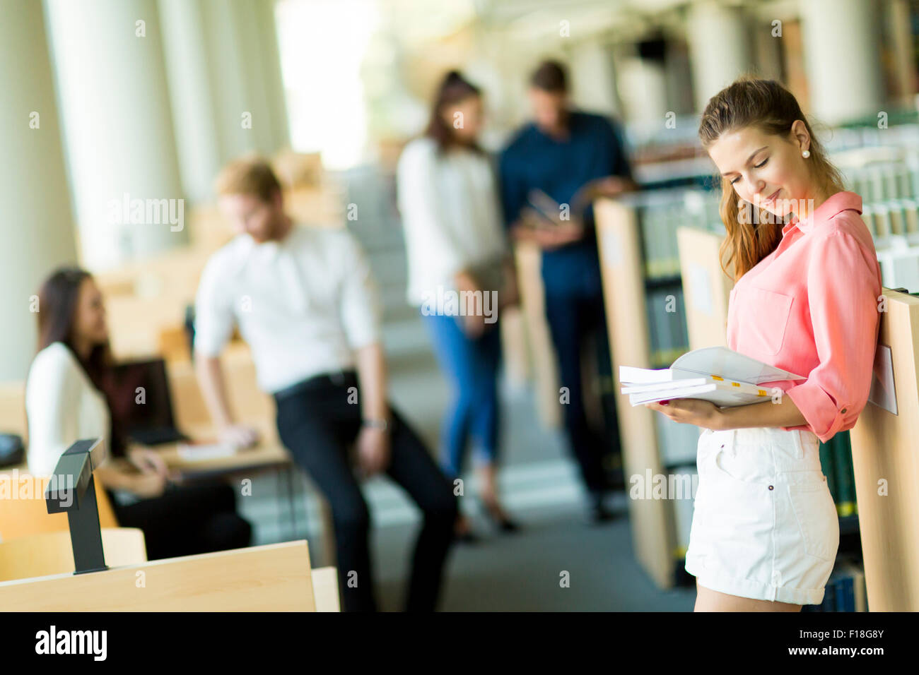 Young woman in the library Stock Photo - Alamy