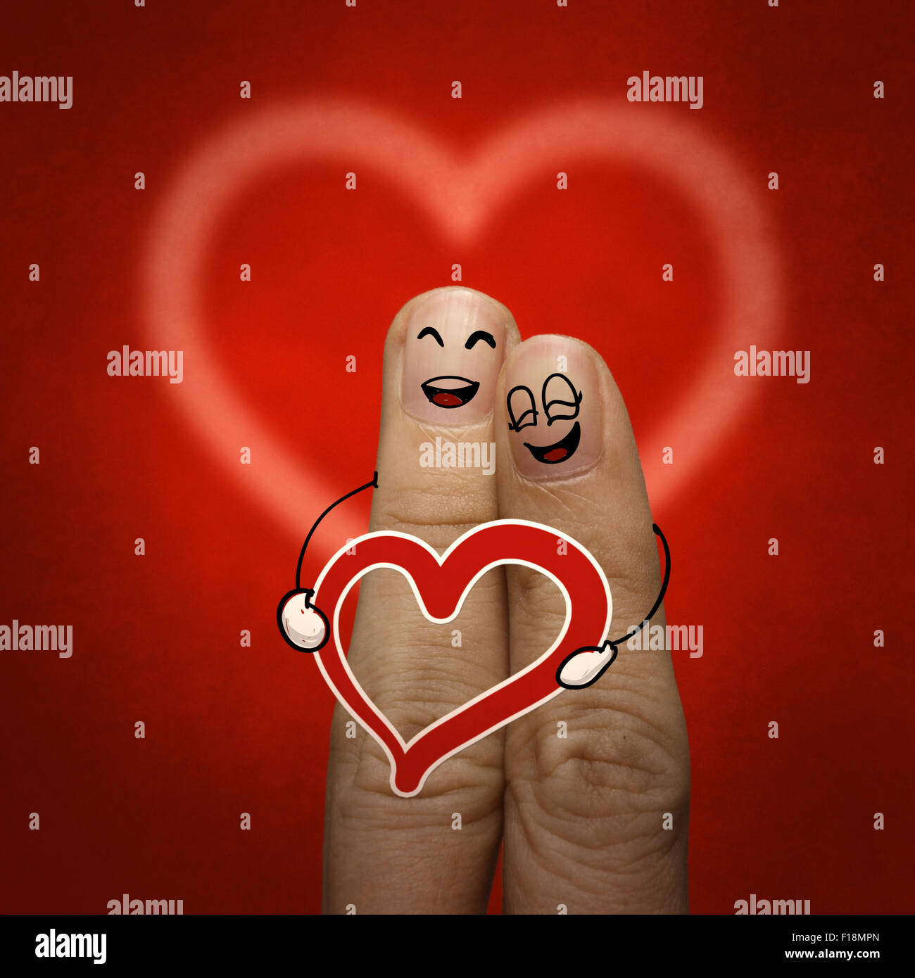 the happy finger couple in love with painted smiley and hold heart as ...