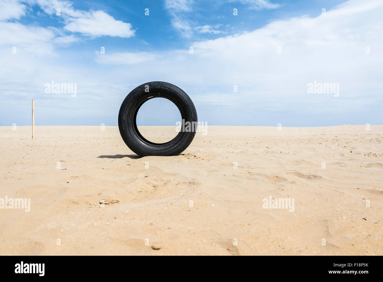 solitary tire submerged by sand on the beach in Rimini in Italy during ...