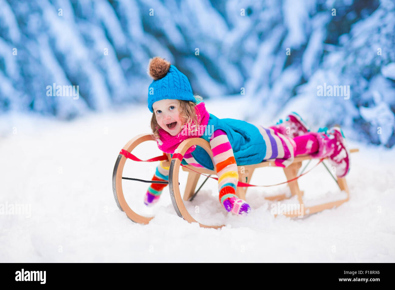 Little girl enjoying a sleigh ride. Child sledding. Toddler kid riding ...