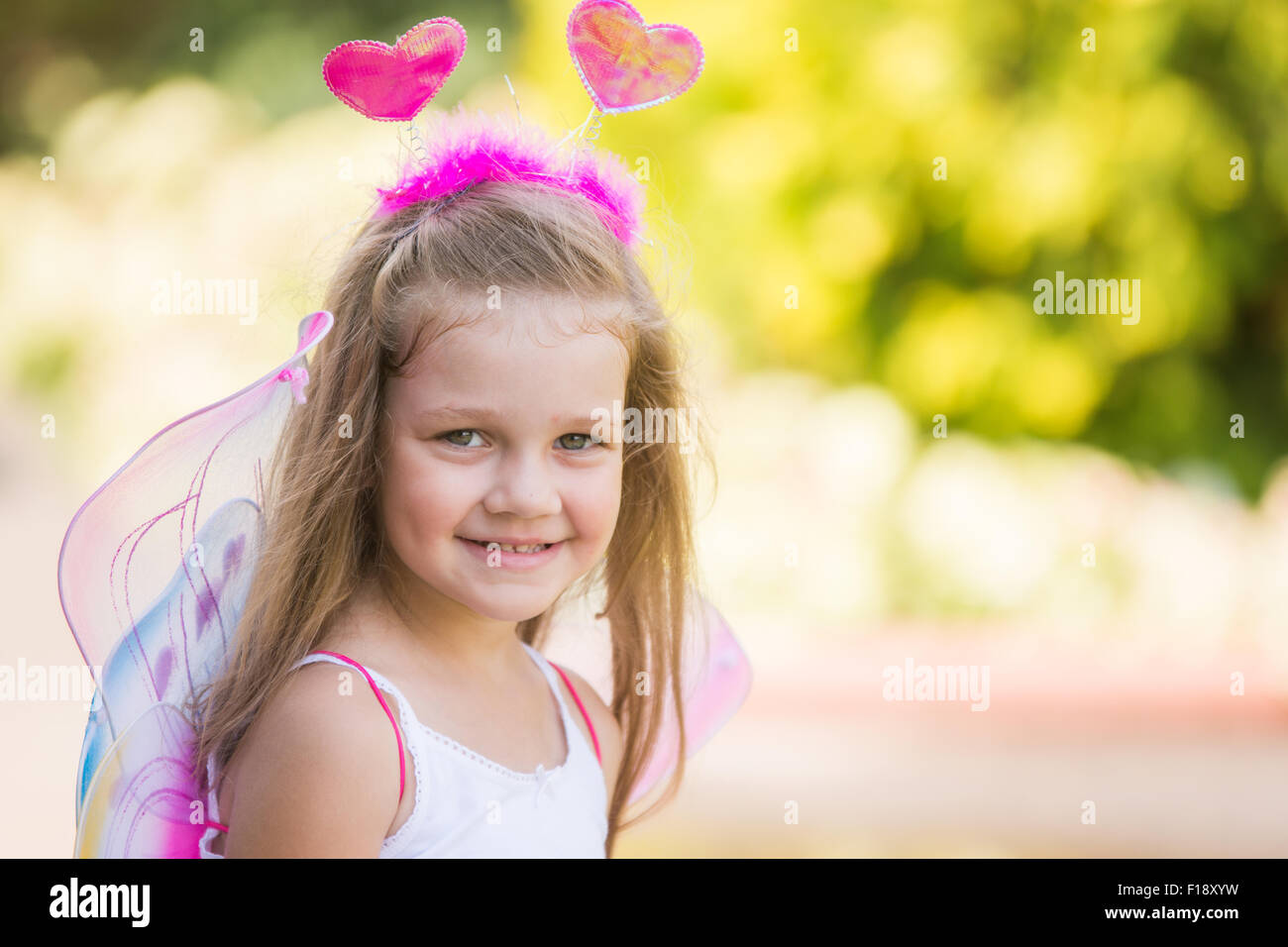 happy four-year-girl in a fairy dress with wings on his back and ...