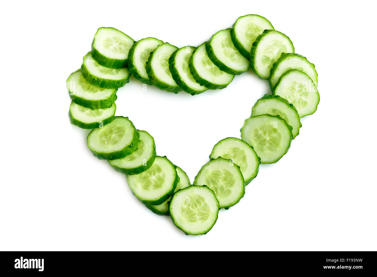 Cucumber slices arranged as heart shape isolated over white background ...