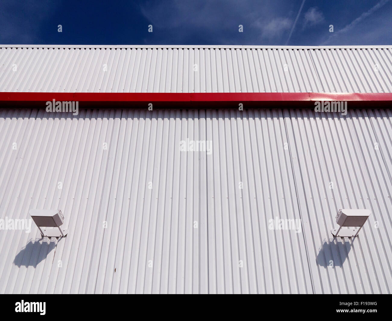 Two white lights on the side of a white steel-paneled structure with ...
