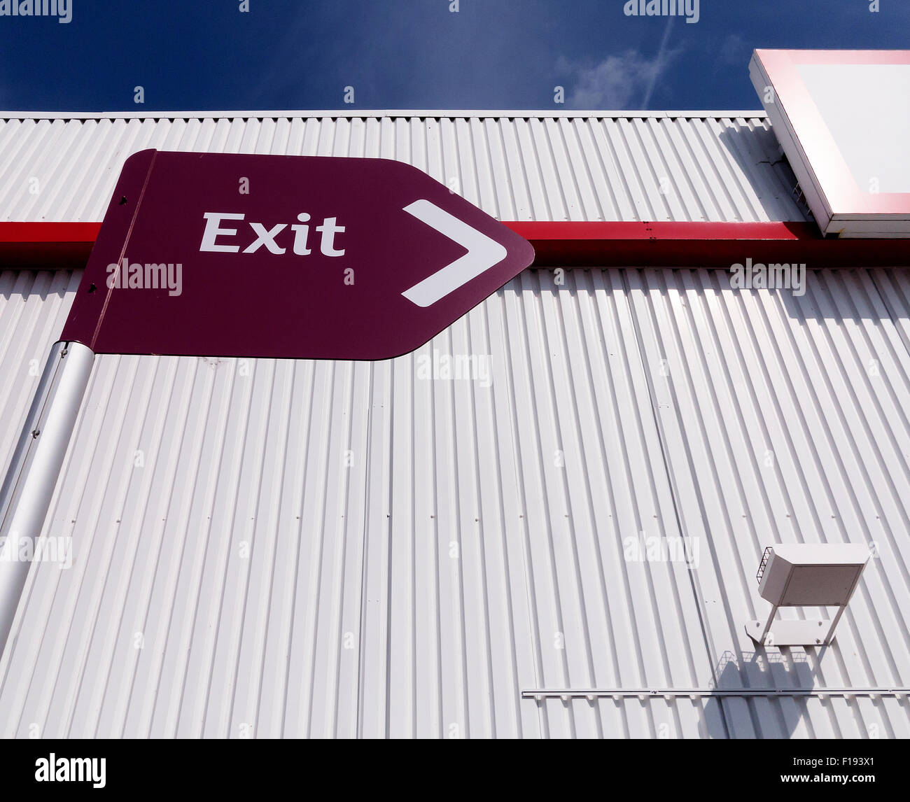 Exit sign in front of a white wall on a sunny day Stock Photo - Alamy