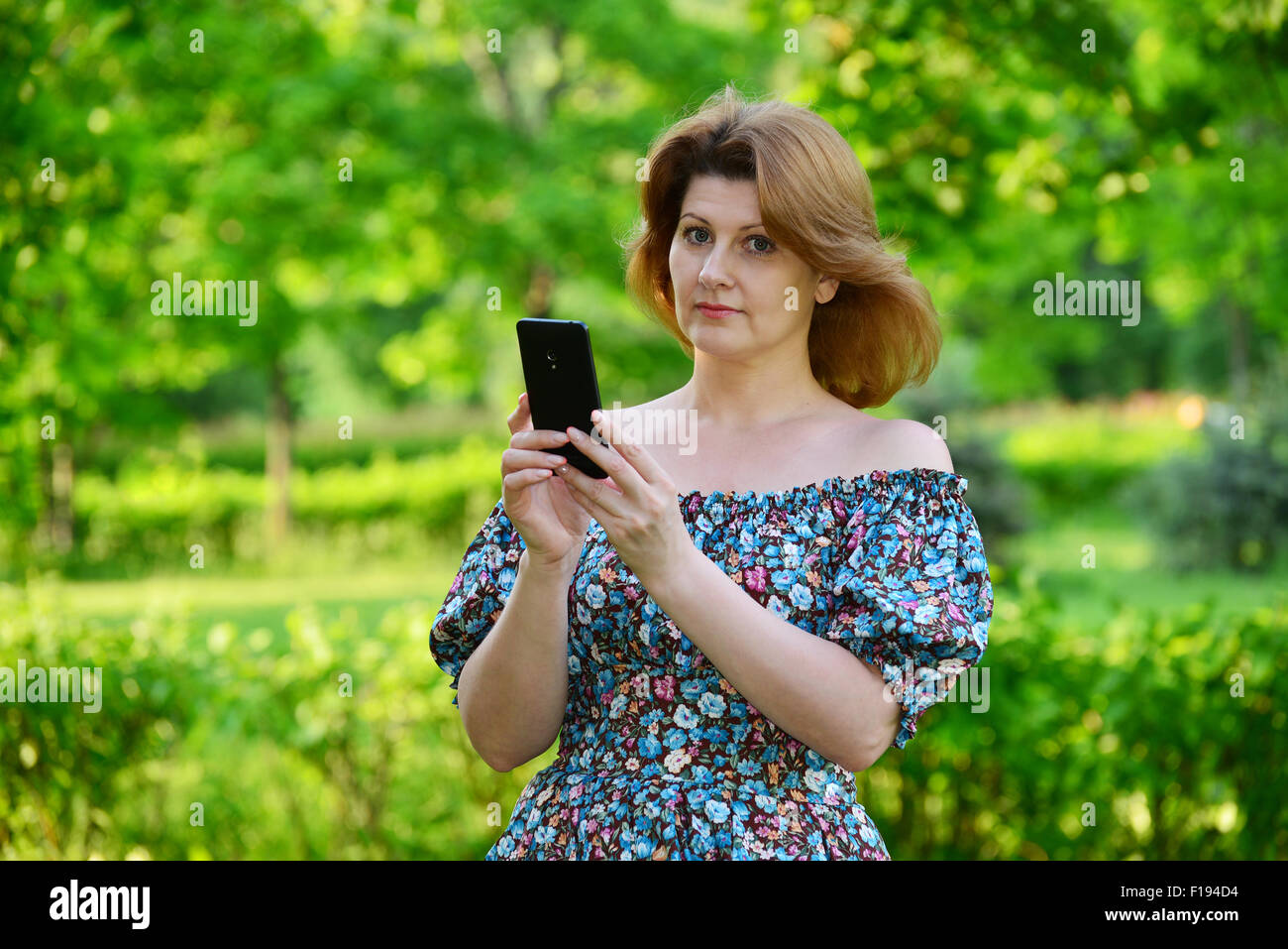 woman with a cell phone in nature at the summer Stock Photo - Alamy