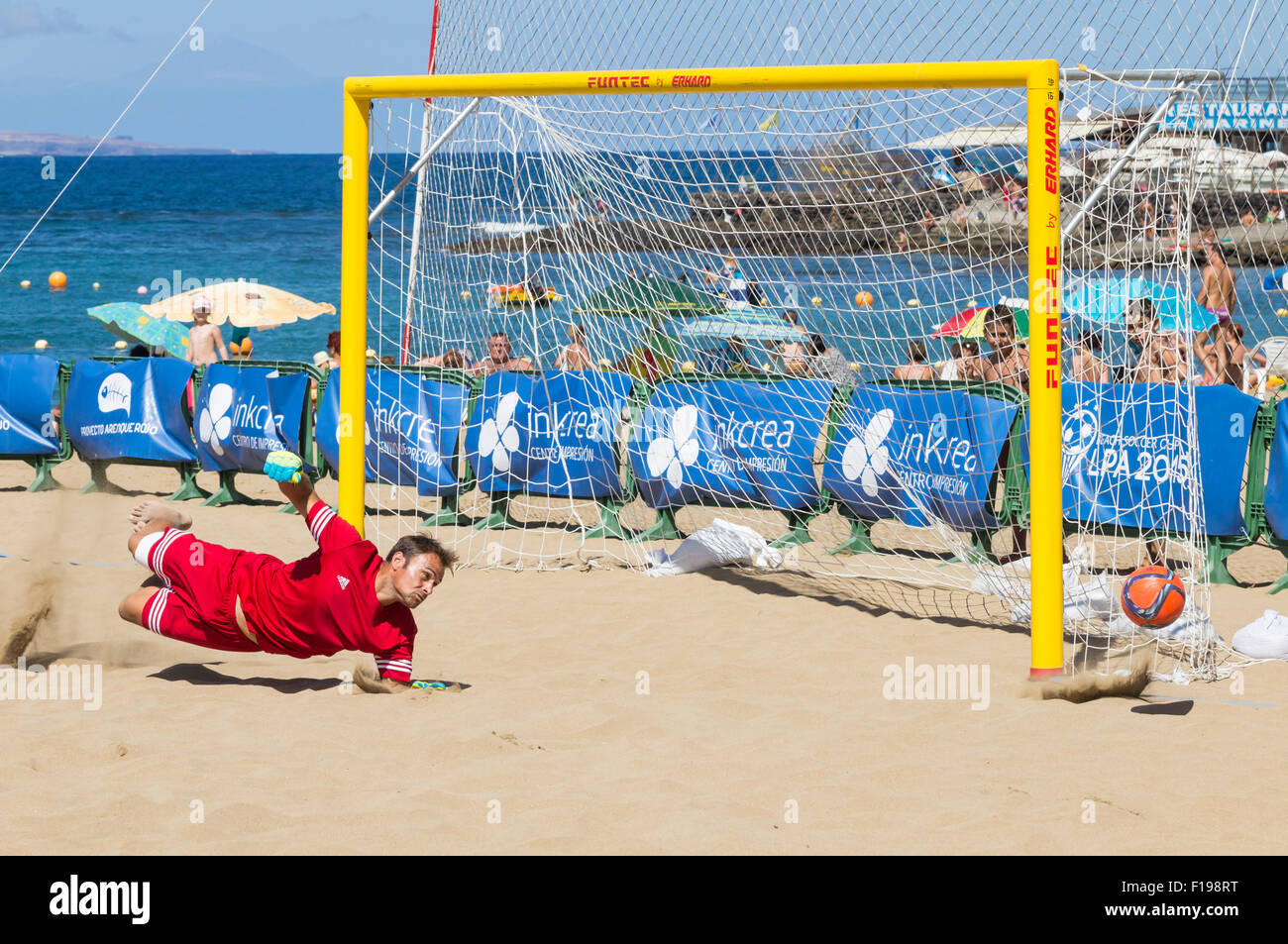Goalkeeper diving at beach football tournament in Spain Stock Photo - Alamy