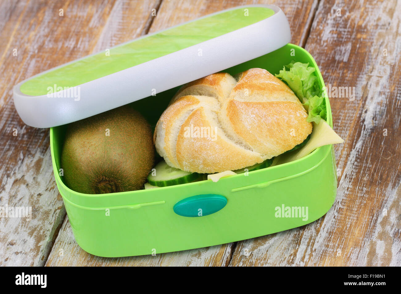 Lunch box with cheese bread roll and kiwi fruit Stock Photo - Alamy
