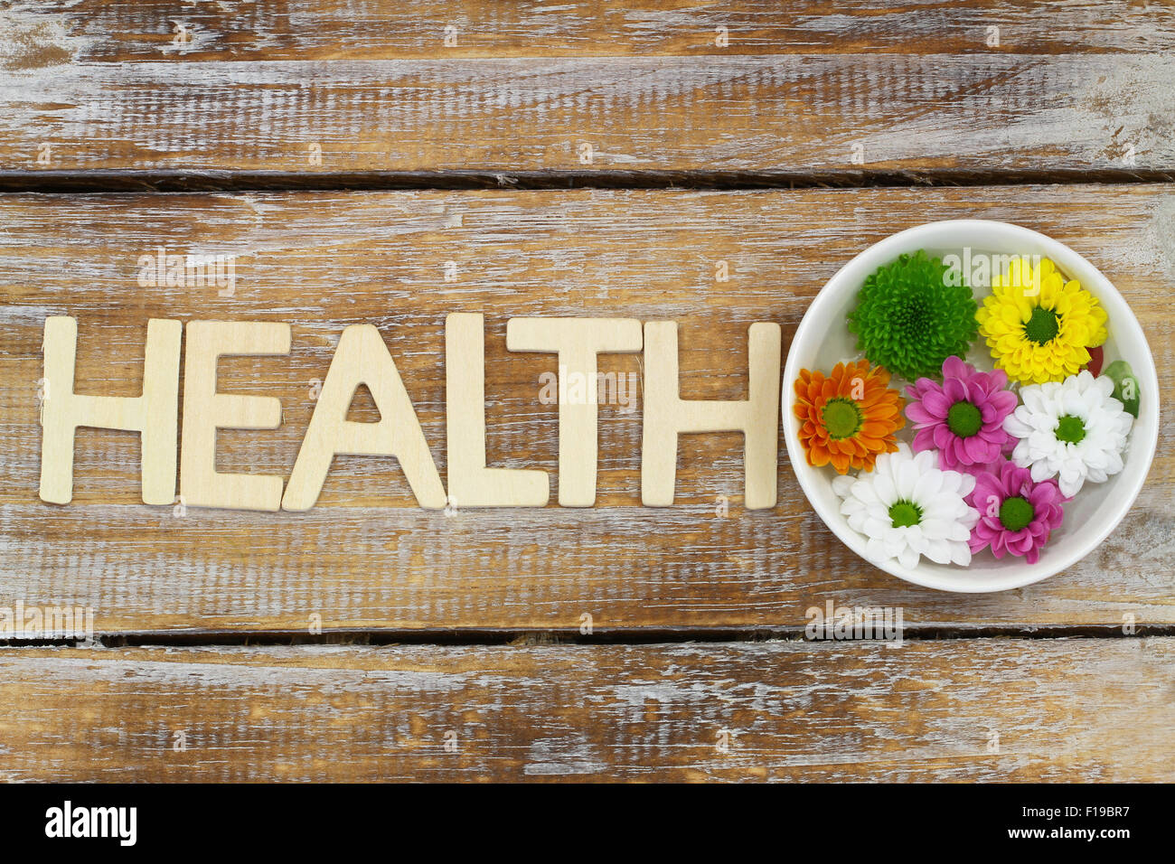 Health written with wooden letters on rustic surface with Santini ...