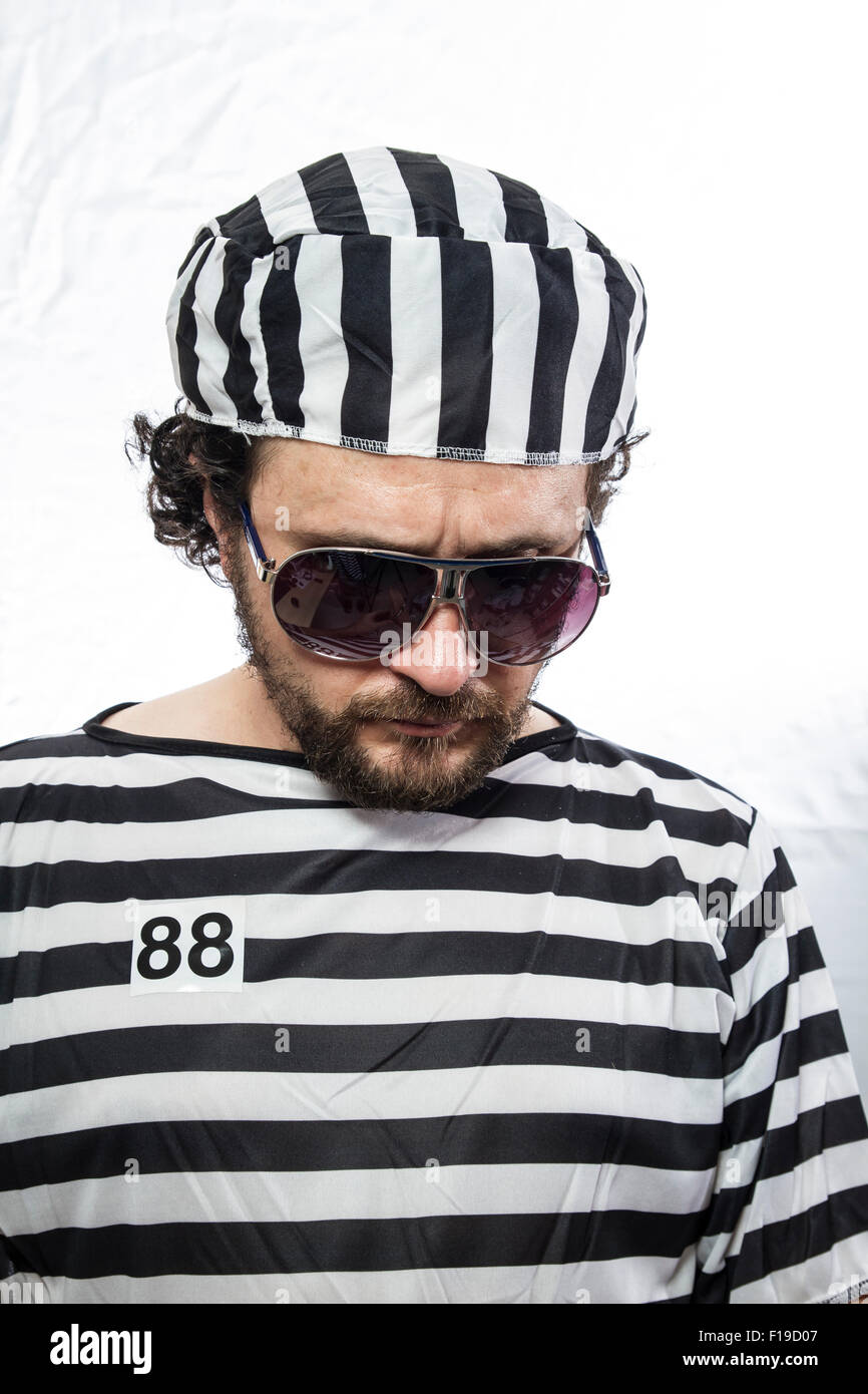 Desperate, portrait of a man prisoner in prison garb, over white ...