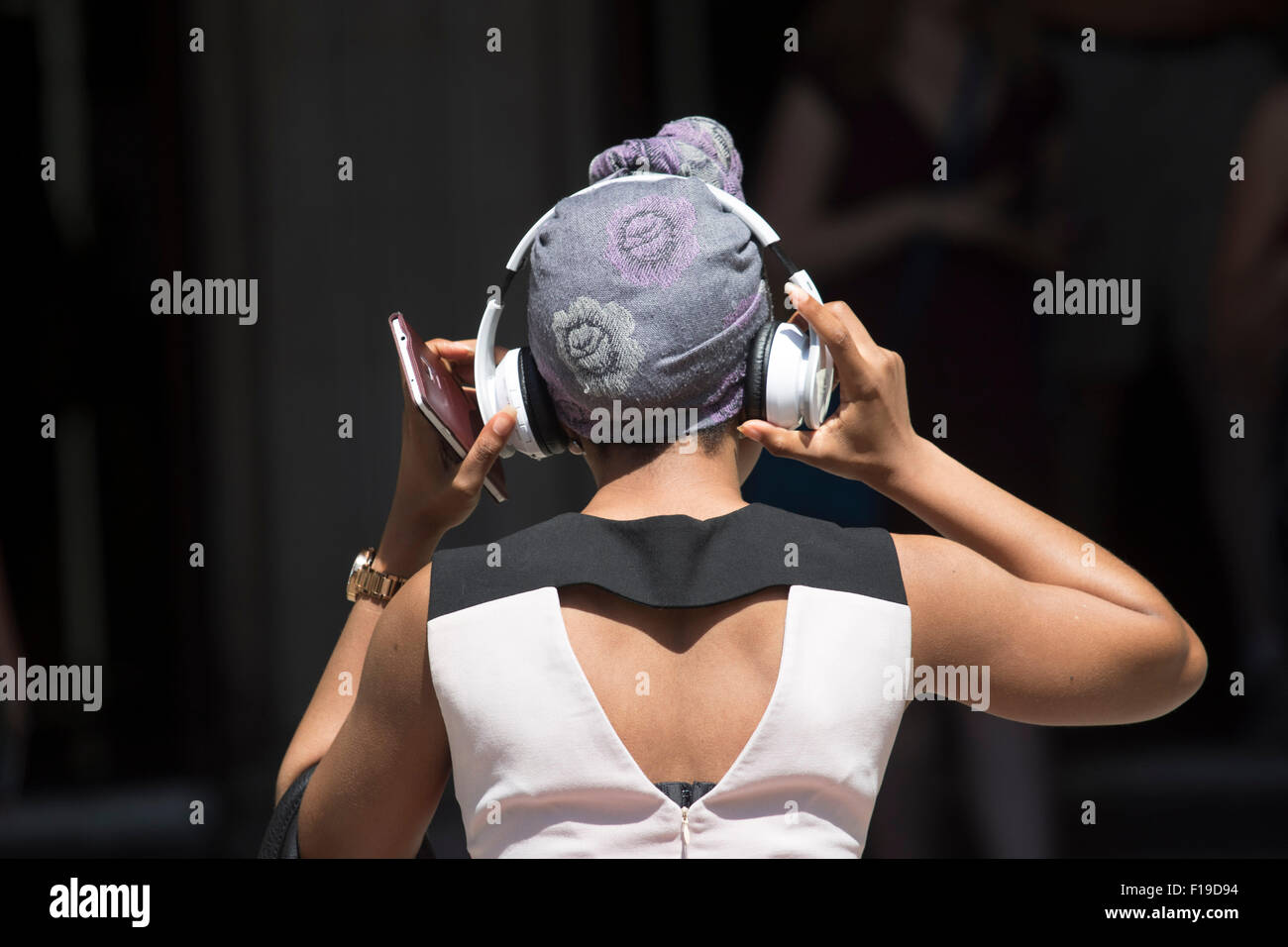 Woman with white big headphones listening back view Stock Photo - Alamy