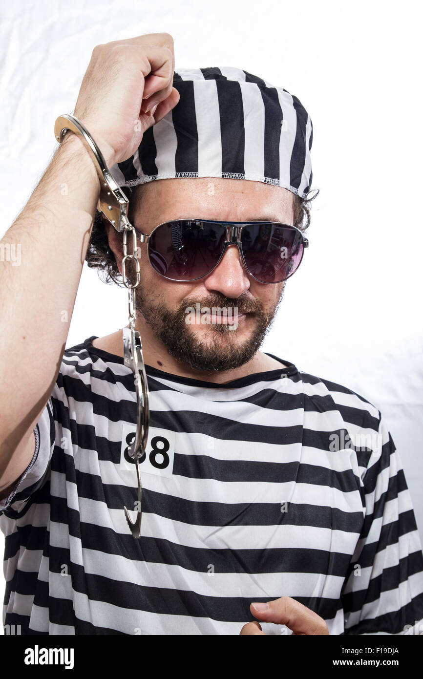 Desperate, portrait of a man prisoner in prison garb, over white ...