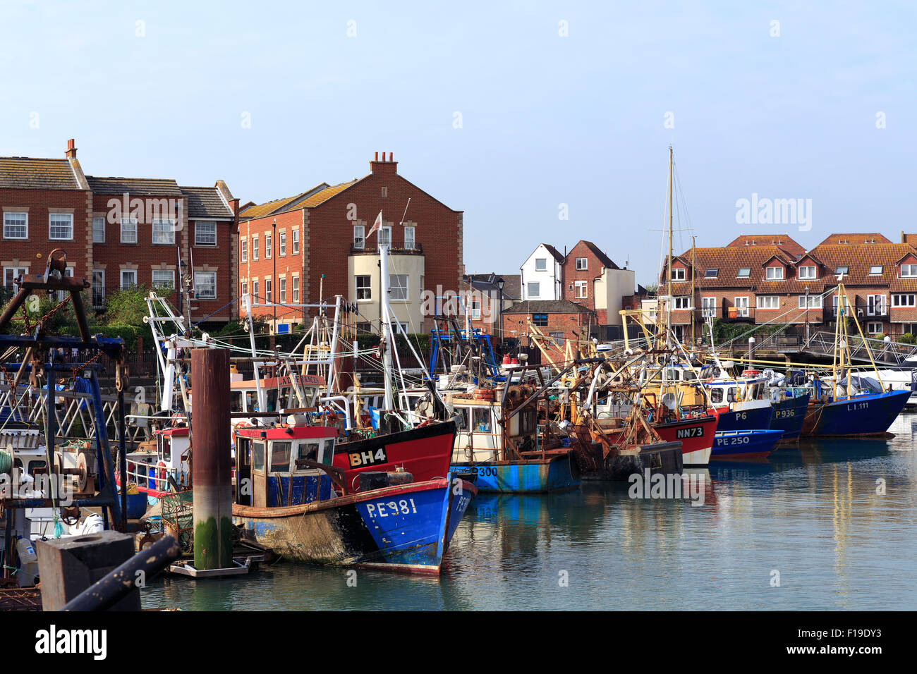 Crowded fishing port in old Portsmouth. Row of boats tied up in the ...