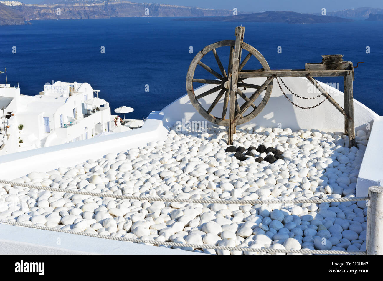A decorative wheel on white cobble stones in Oia, Santorini, Greece ...