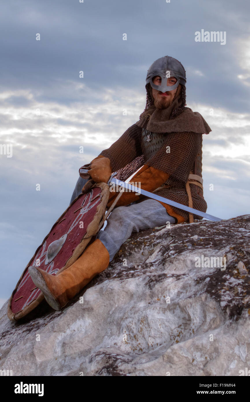 Knight sitting on a rock with a sword against blue cloudy sky Stock ...