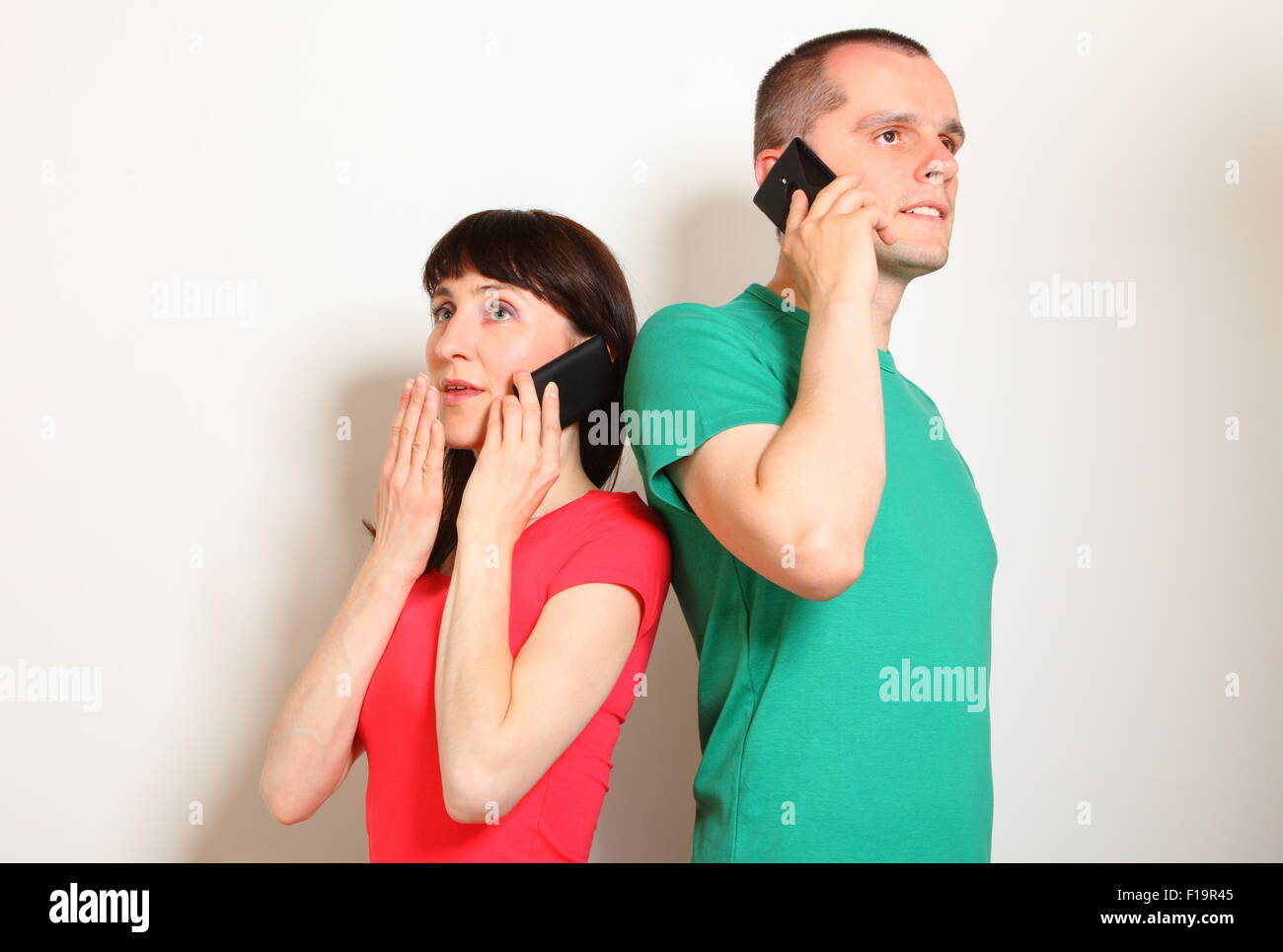Shocked woman and man receive an unexpected message while talking on ...