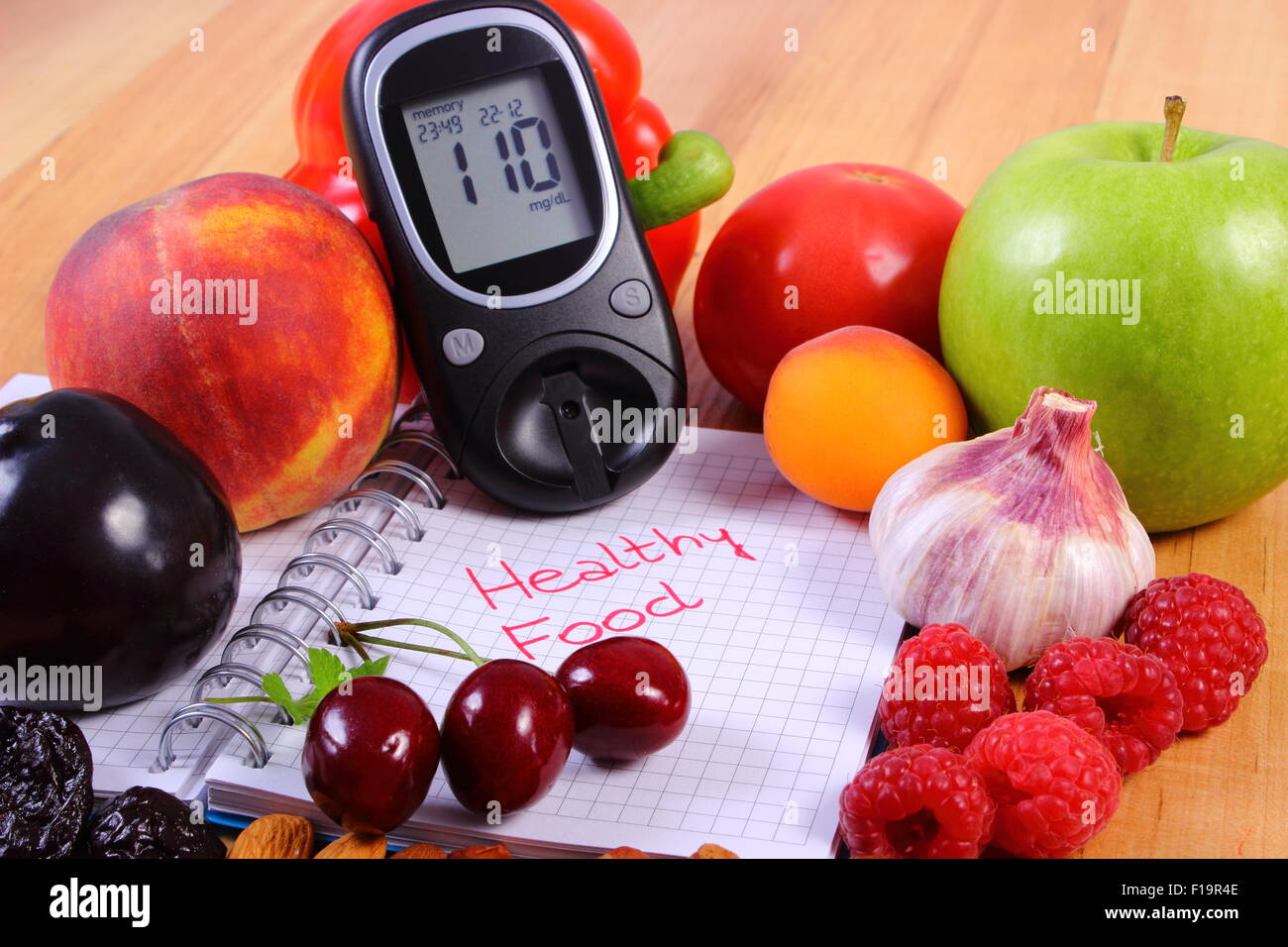 Fresh fruits, vegetables and glucose meter on notebook for writing ...