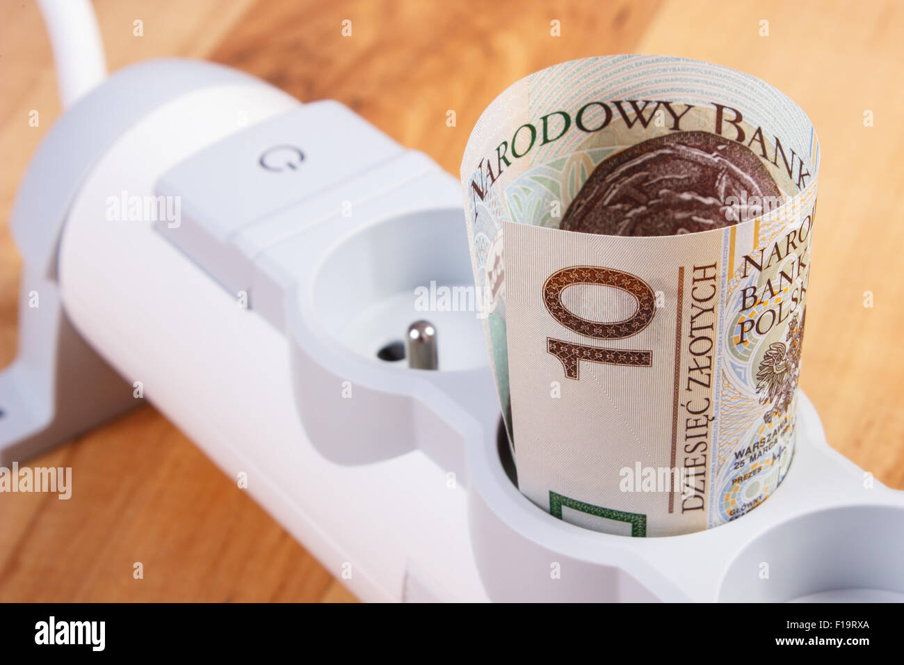 Electrical extension with polish currency money on wooden floor, power ...