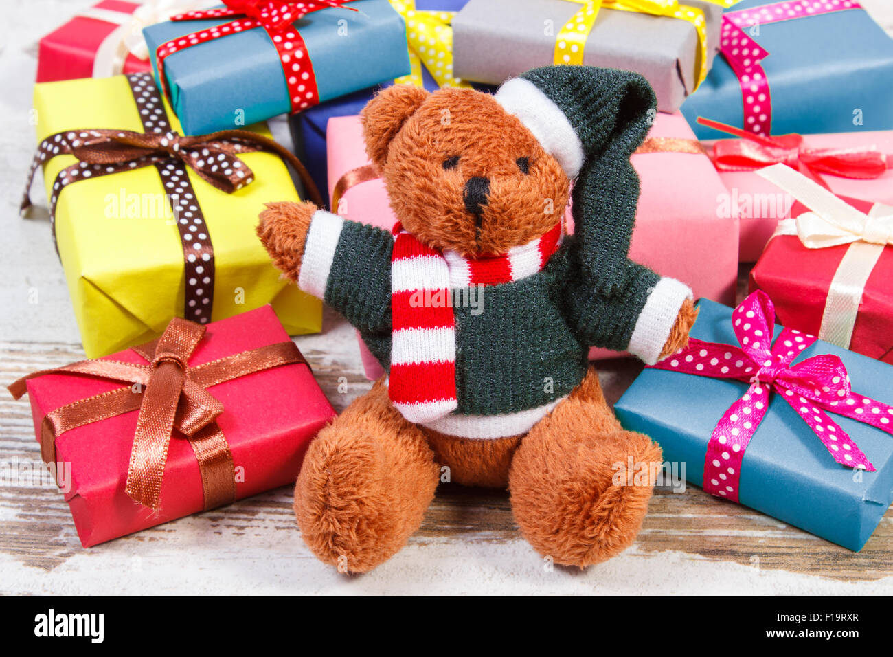 Fluffy teddy bear and heap of wrapped colorful gifts for Christmas ...