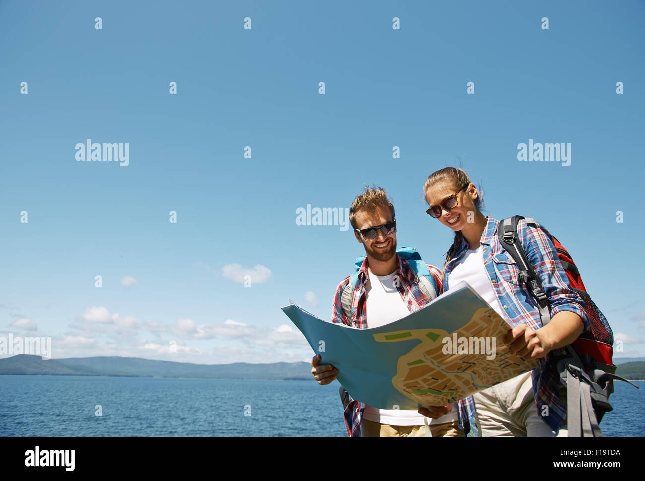 Cheerful hikers looking at guide during their trip Stock Photo - Alamy