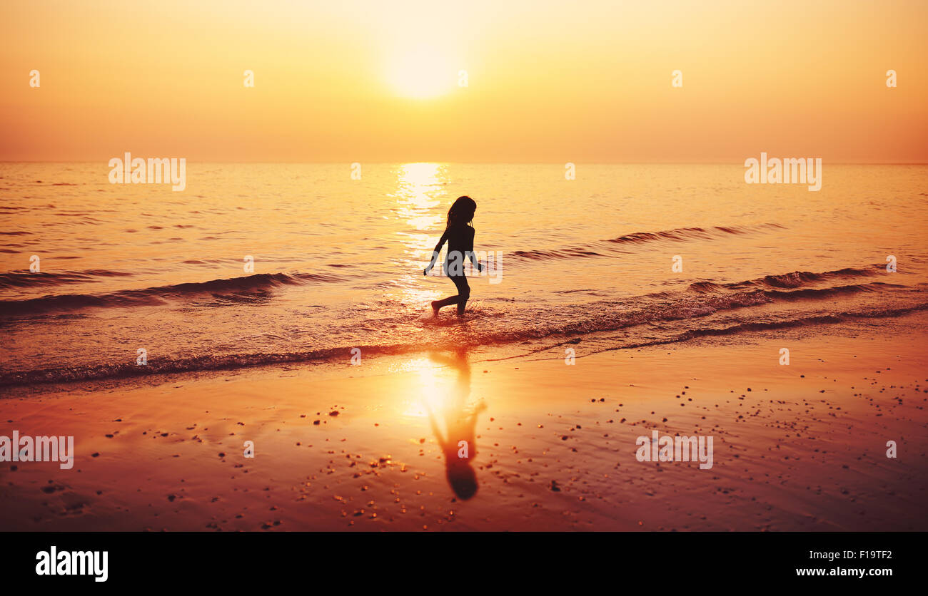 Child running beach during sunset Stock Photo - Alamy