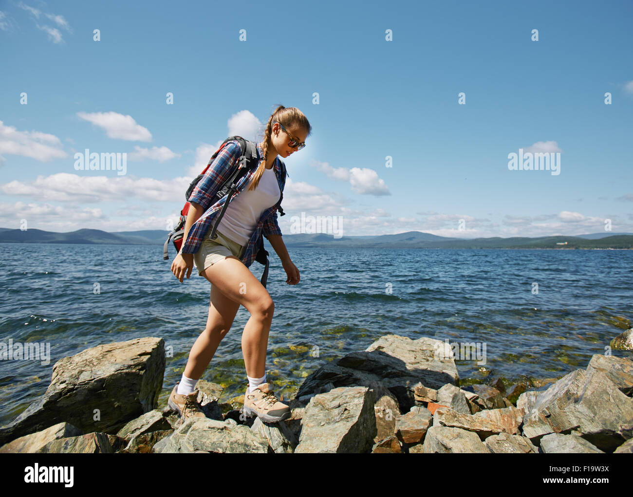 Pretty hiker walking on rocks by the seaside Stock Photo - Alamy