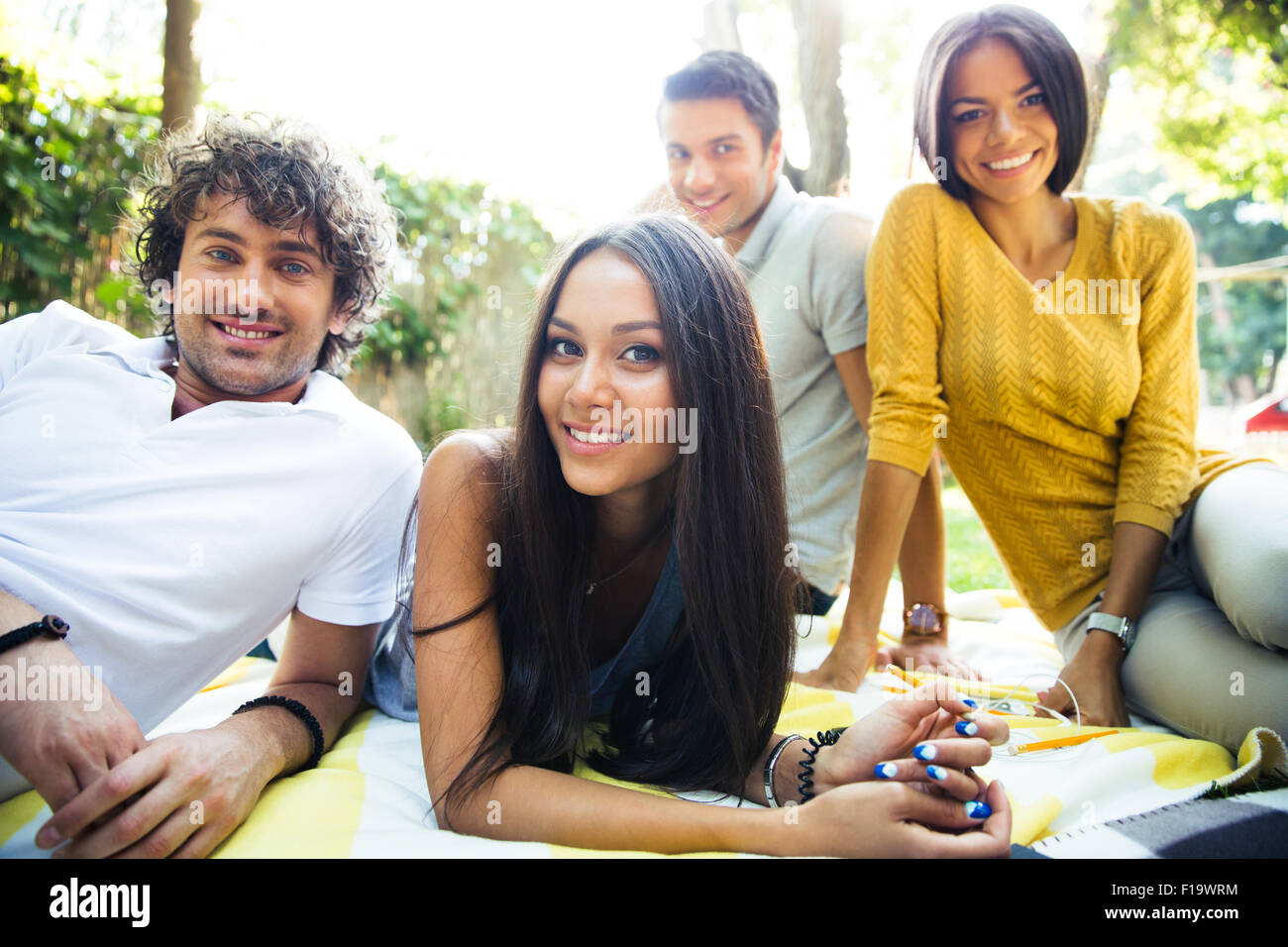 Portrait of a happy friends resting outdoors in campus Stock Photo - Alamy