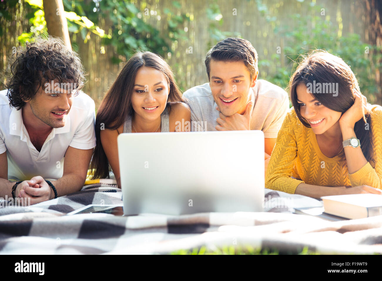Group friends laughing using laptop hi-res stock photography and images ...