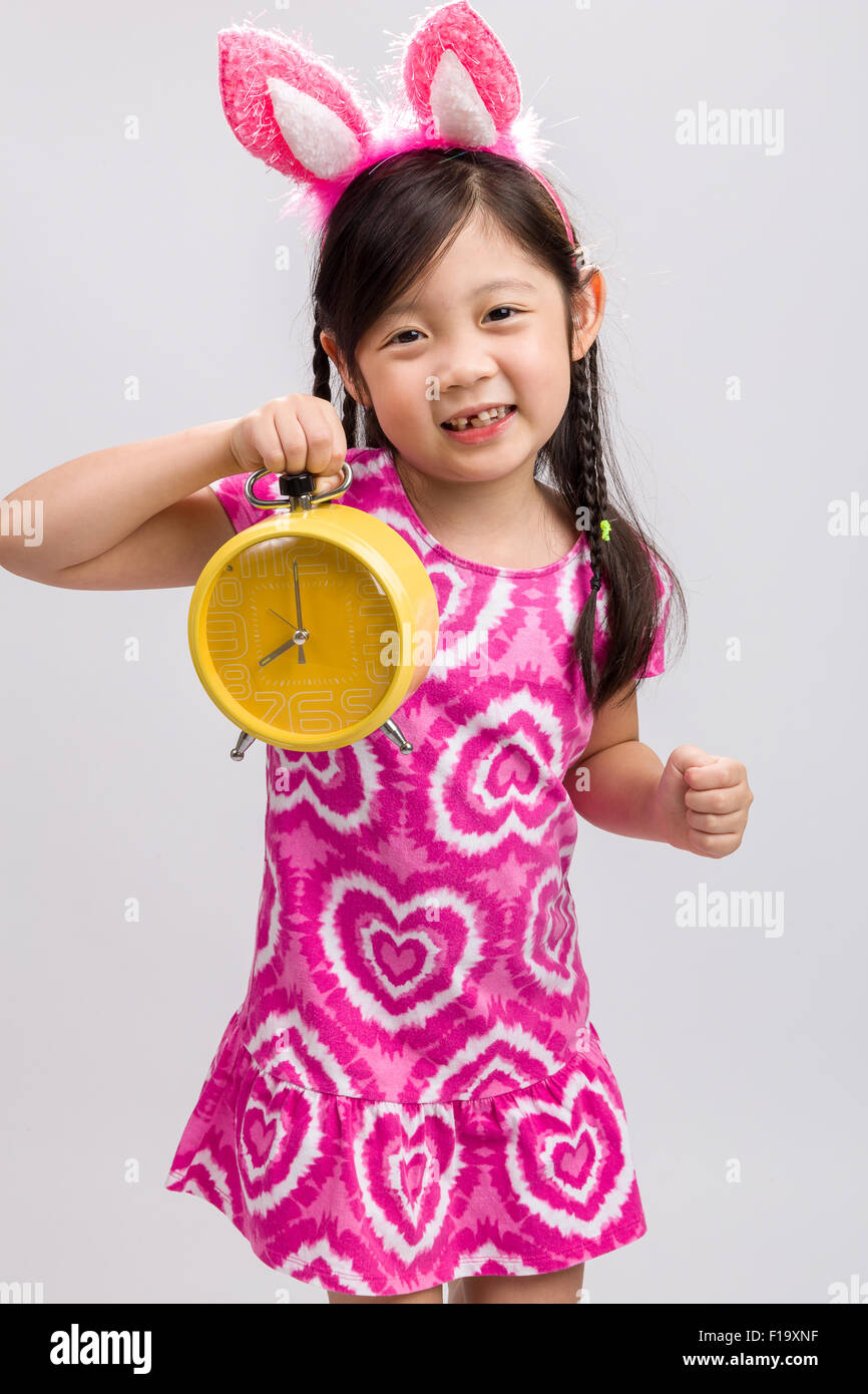 Child holding clock illustrating time concept on white background Stock ...
