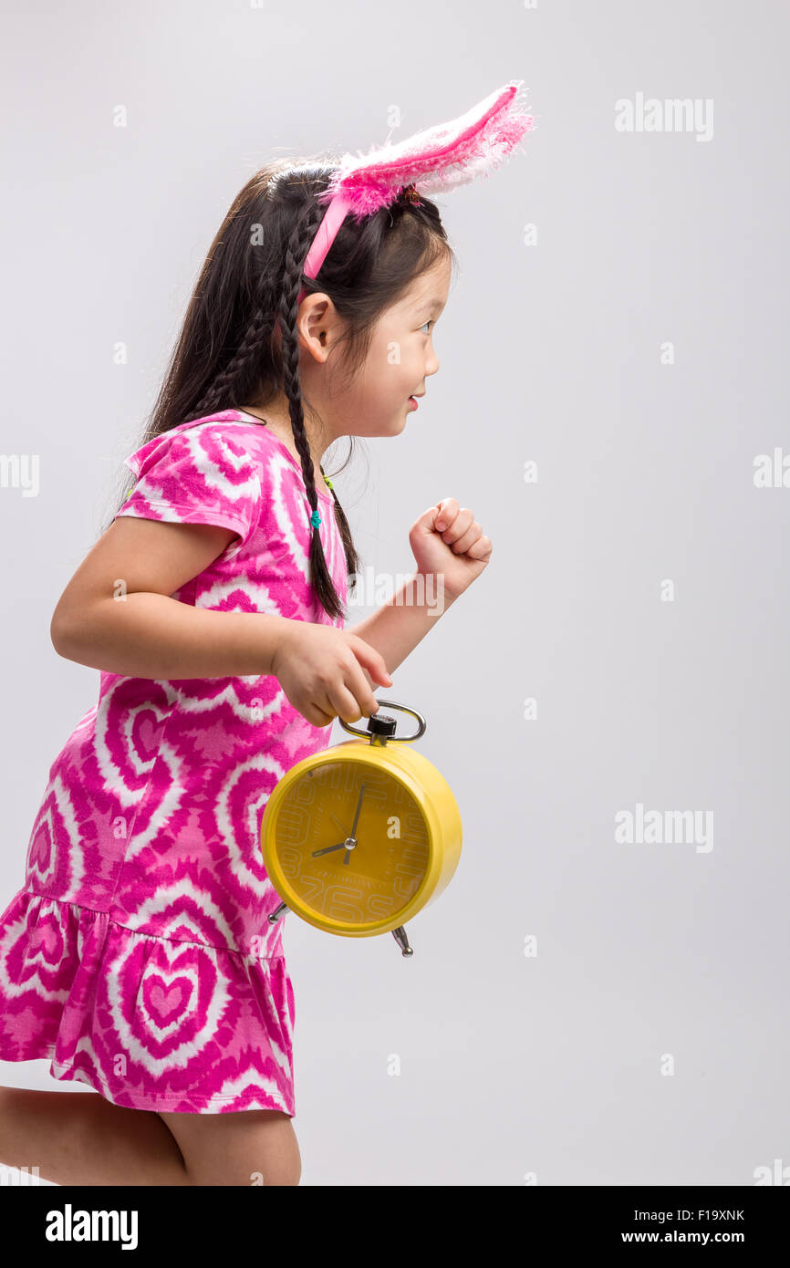 Child holding clock illustrating time concept on white background Stock ...