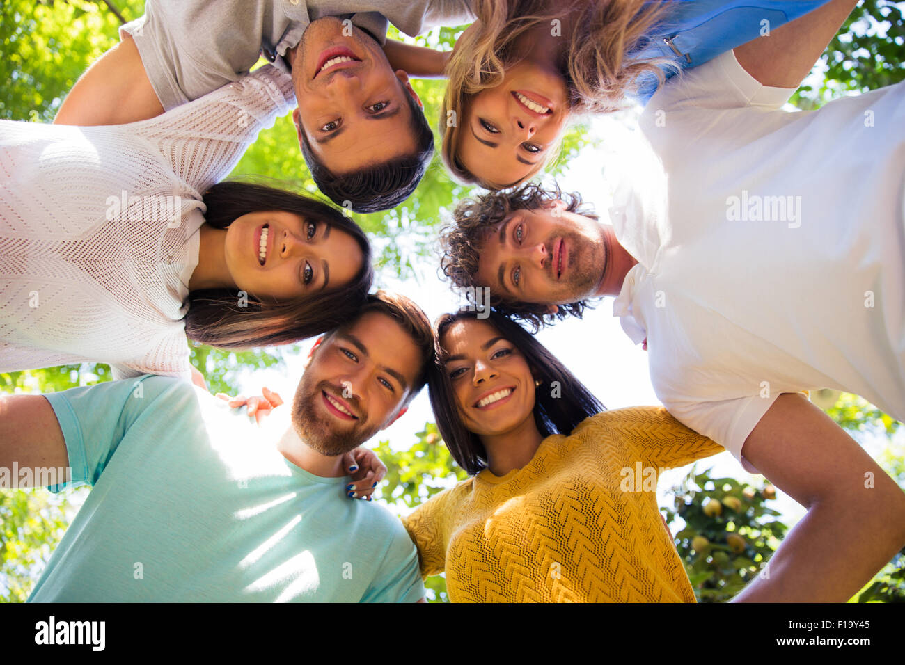 Group of smiling friends hugging together at the park in a circle Stock ...